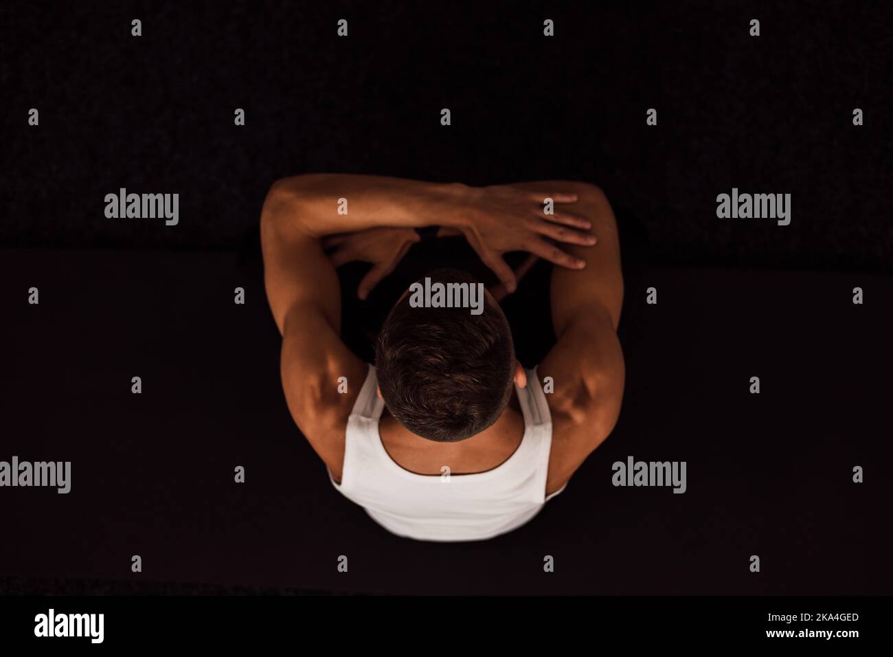 A man holds his knees with his hands doing yoga. Top view Stock Photo ...