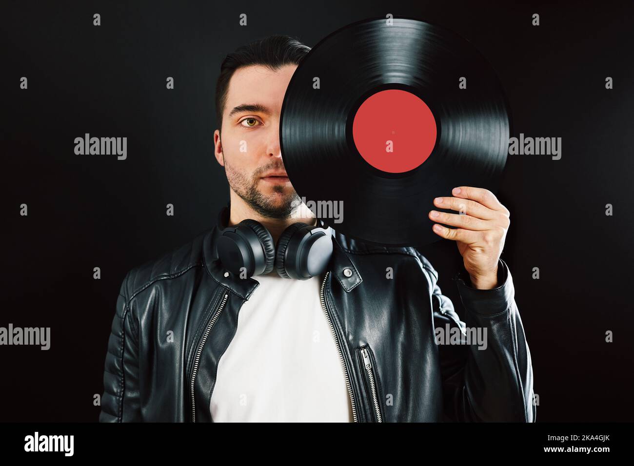 Man holding retro vinyl record covering face. Rock style. Vintage music ...