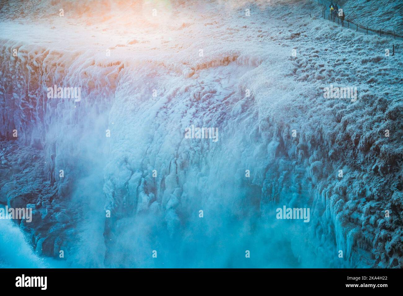 An ice waterfall covered in steam during northern lights on a snowy day ...