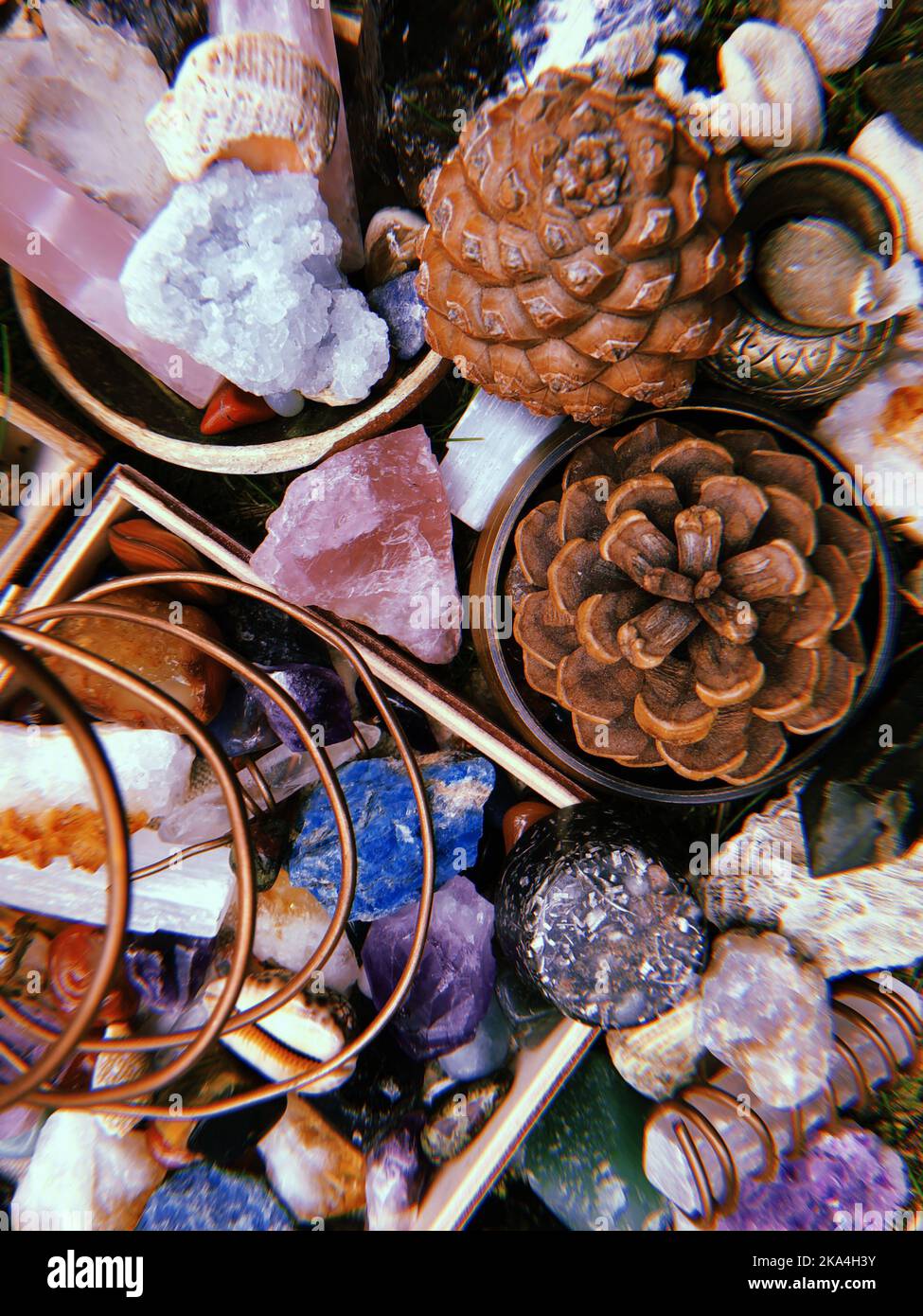 A top view of pine cones and colorful crystal healing stones for ...