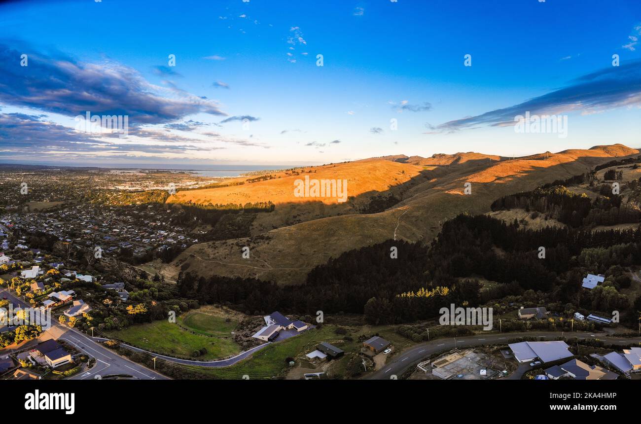 A scenic aerial view of small town and picturesque hills at sunrise ...