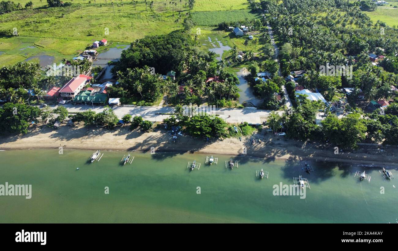An aerial drone shot overlooking the Bayawan City Boulevard and the ...