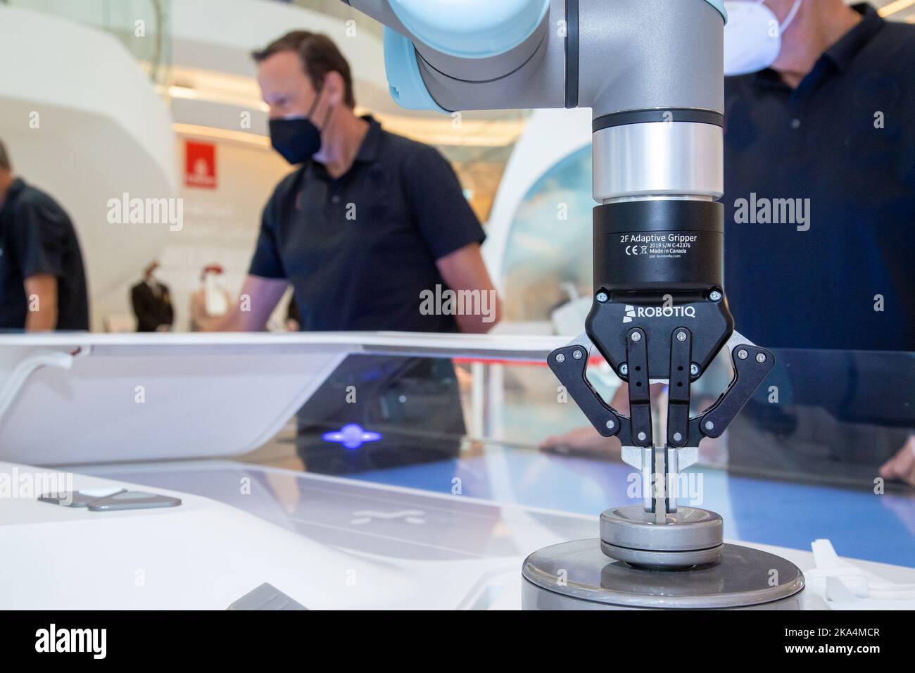 robotic arm with people controlling at back Stock Photo - Alamy