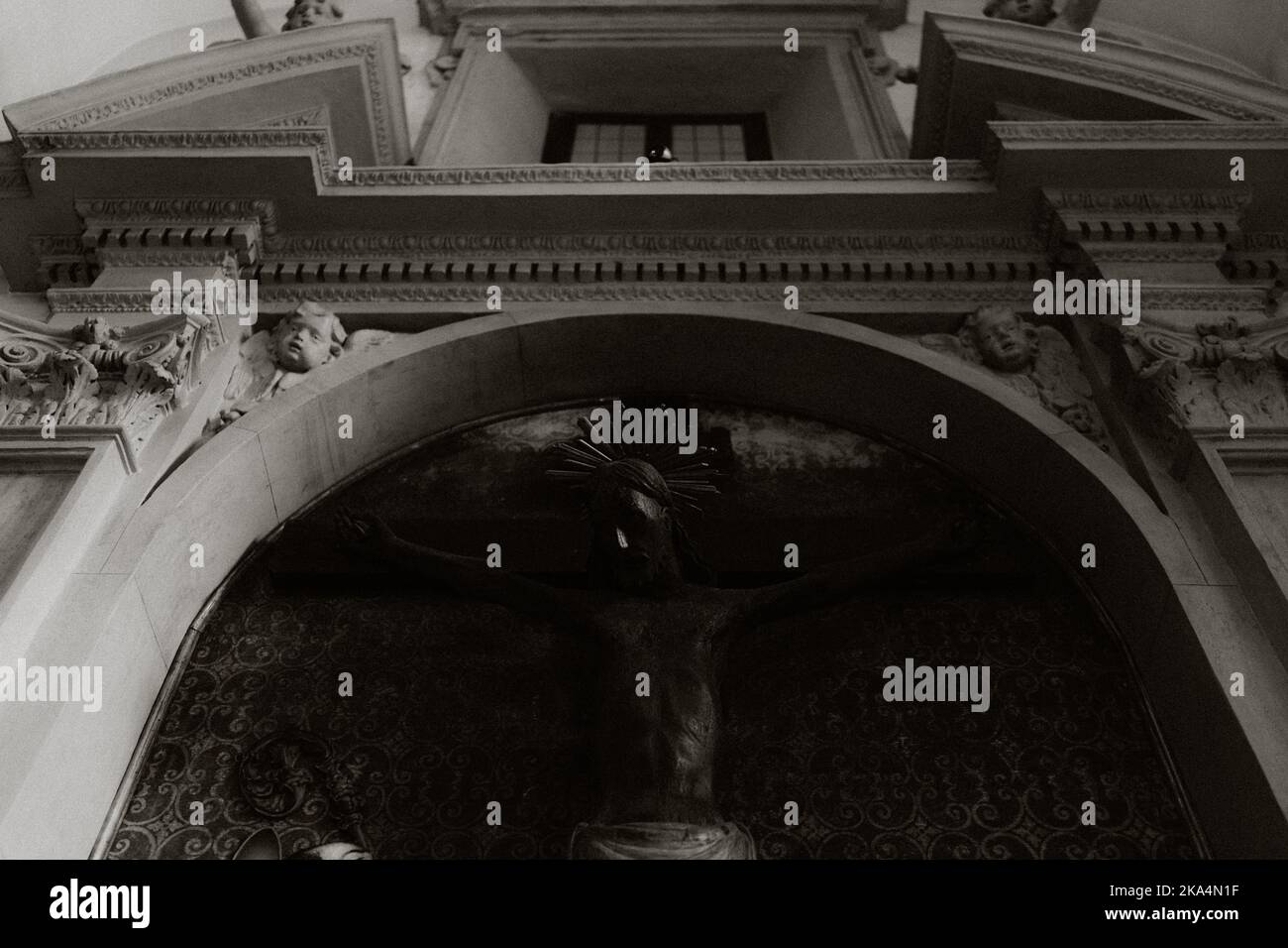 The statue of Jesus on an arch entrance of a Church in greyscale Stock ...