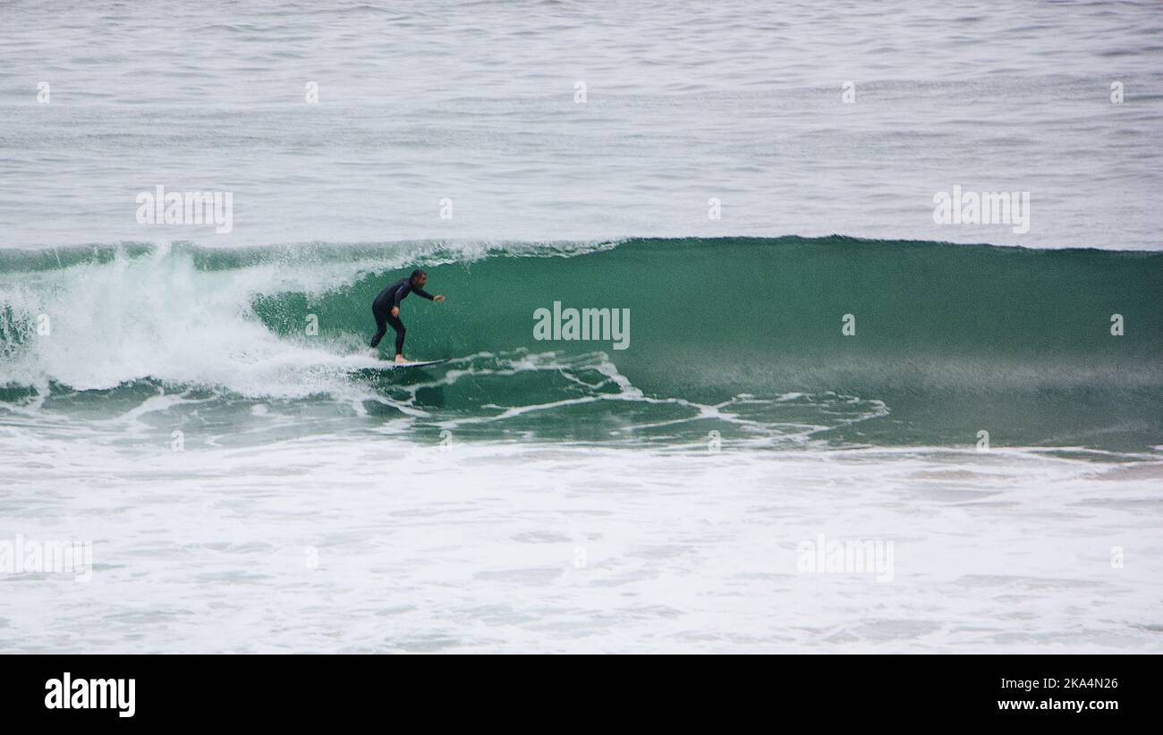 A surfer rides an ocean wave on her surfboard Stock Photo - Alamy
