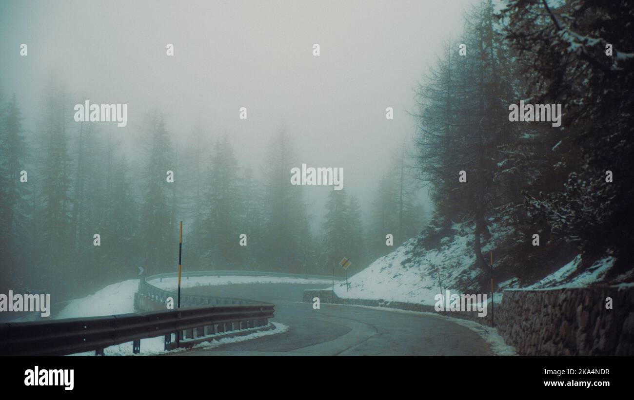 A foggy, curvy road in the snowy forest in South Tyrol, Italy Stock ...
