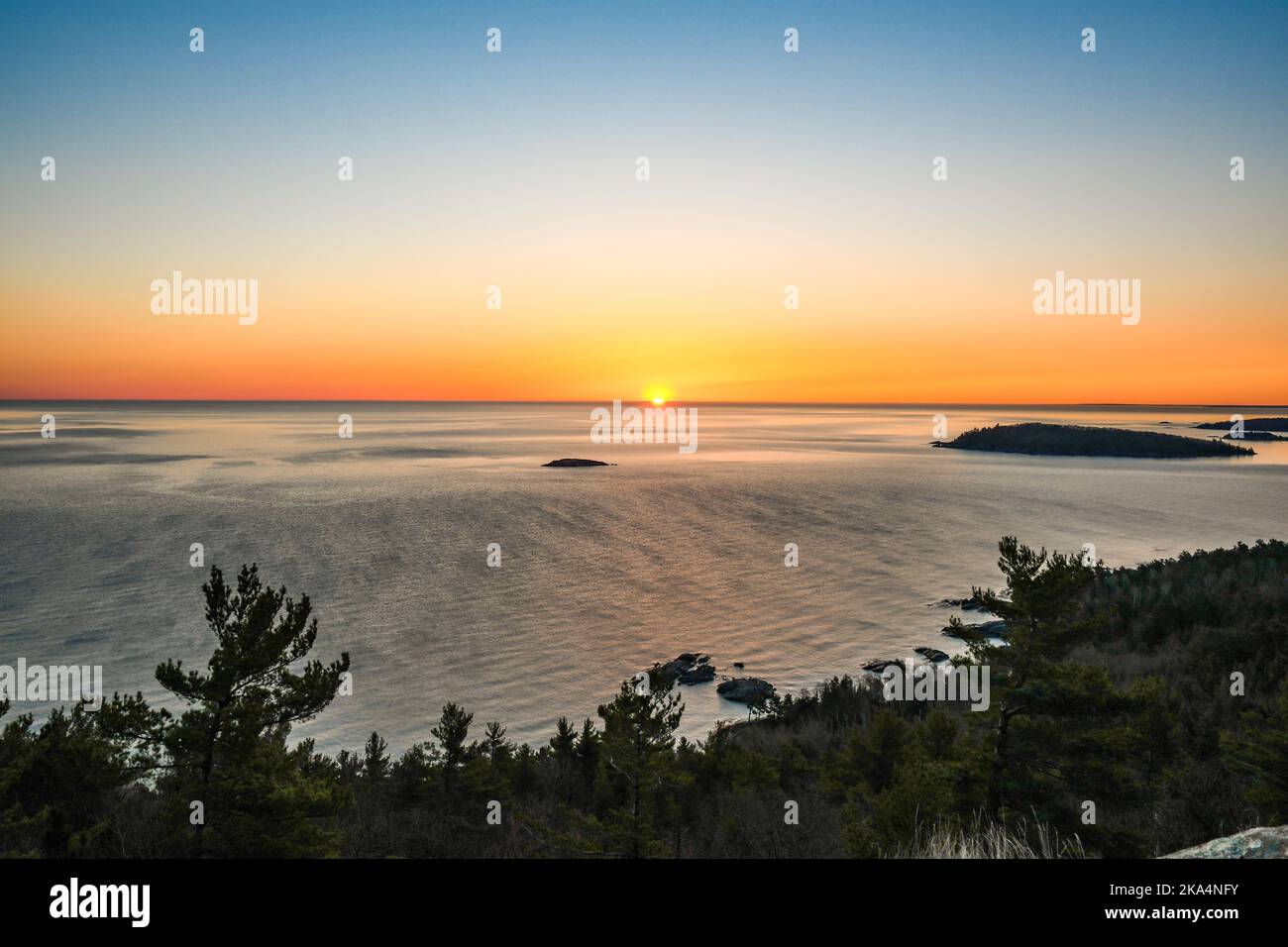 The sun rises over a sleepy Lake Superior. The rich colors of the sun ...