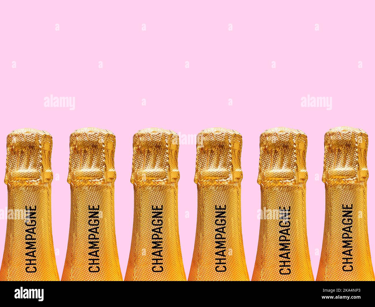Row of champagne bottles covered in gold foil stamped with the word ...