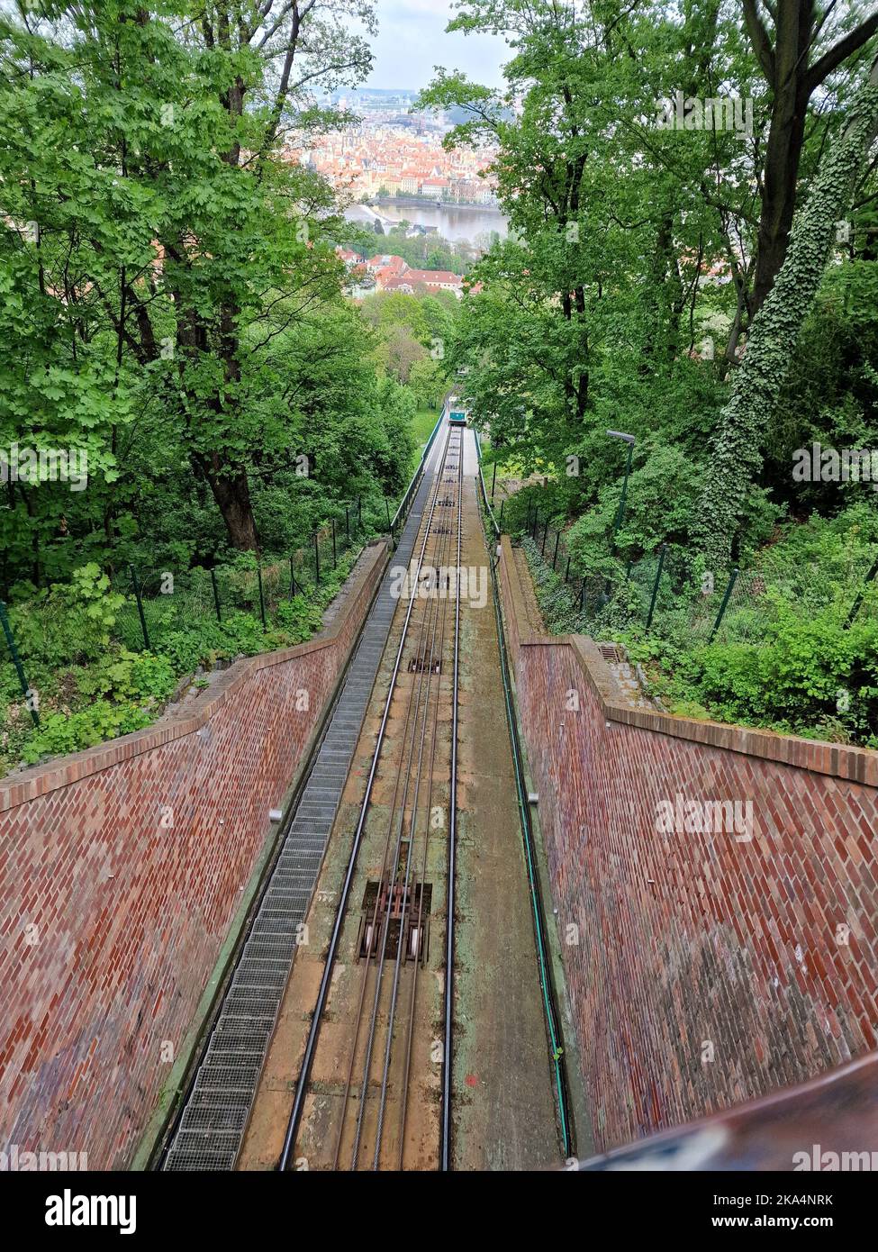 A high angle closeup of a long train railway between stone brick walls ...