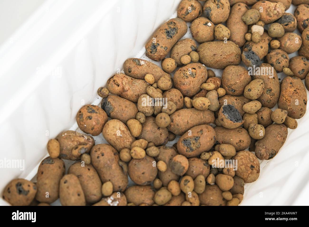 A man falls asleep in a flower box of expanded clay. Soil preparation ...