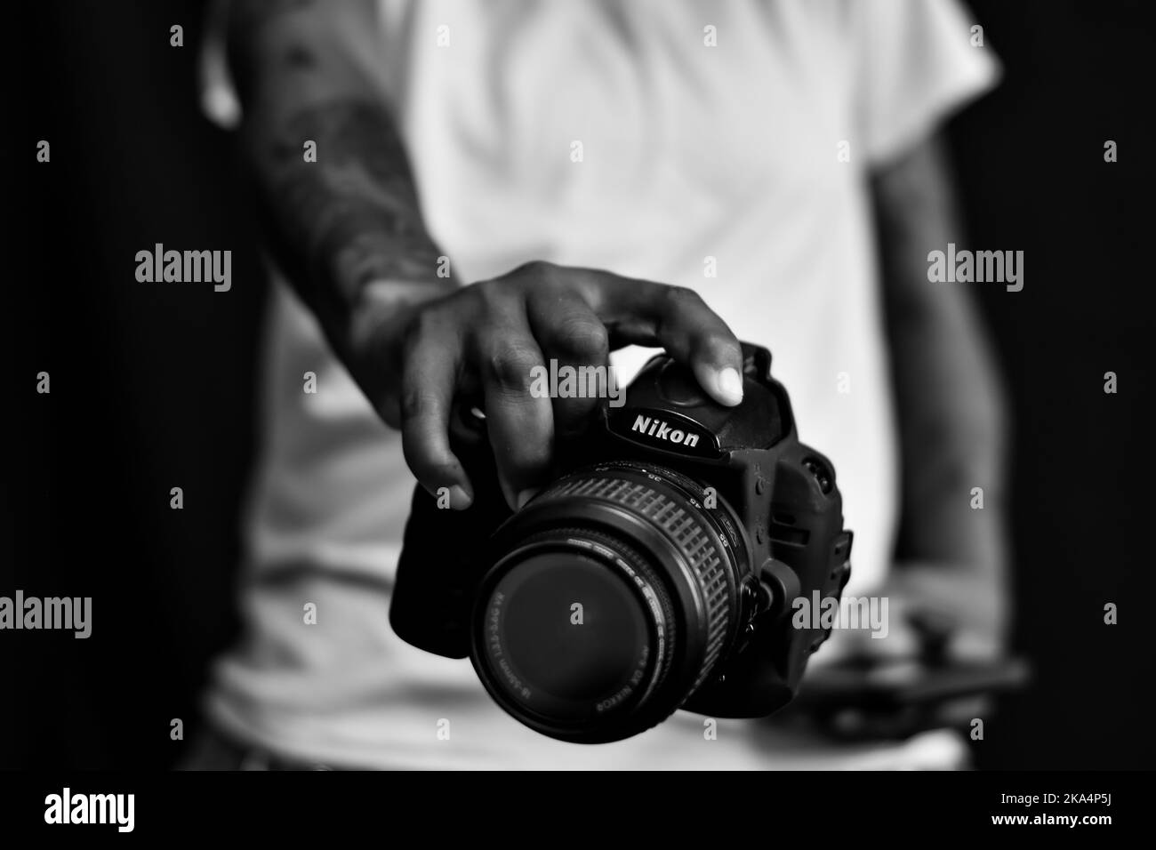 A grayscale of a hand holding a camera with a passion Stock Photo - Alamy