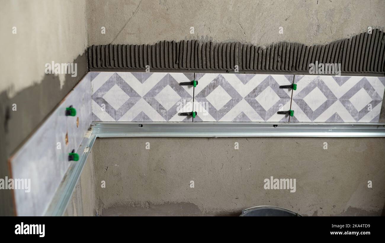 Tiles glued in the bathroom. The process of gluing tiles on the wall ...