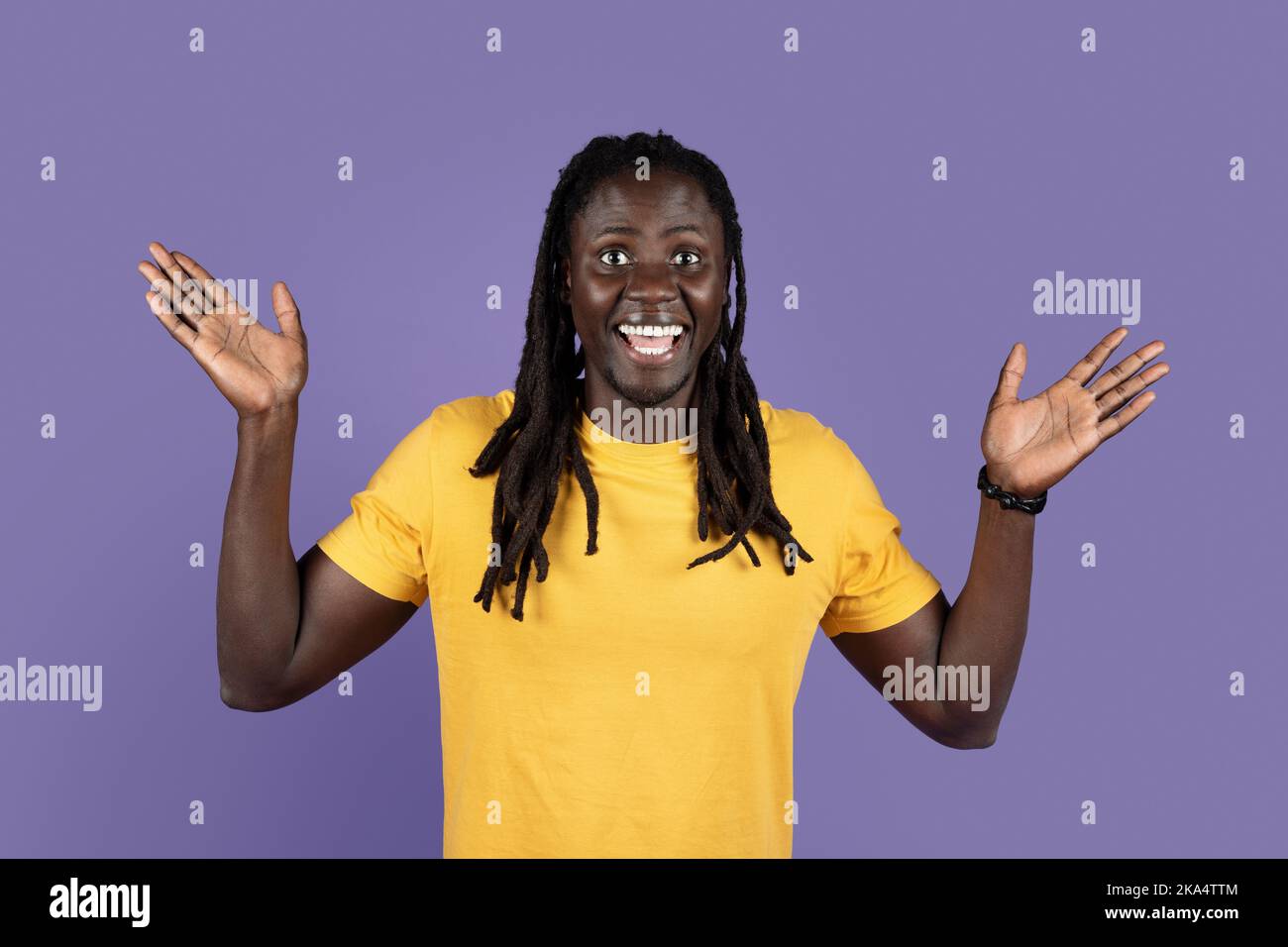 Amazed black guy raising hands up and screaming on purple Stock Photo ...