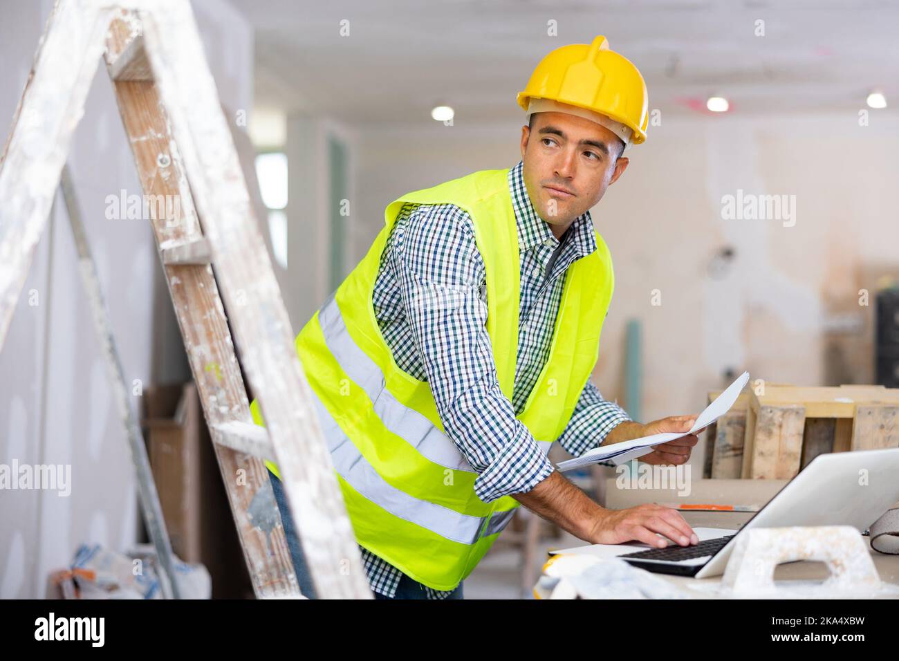 Engineer with drawings in his hands, checks the house reconstruction ...