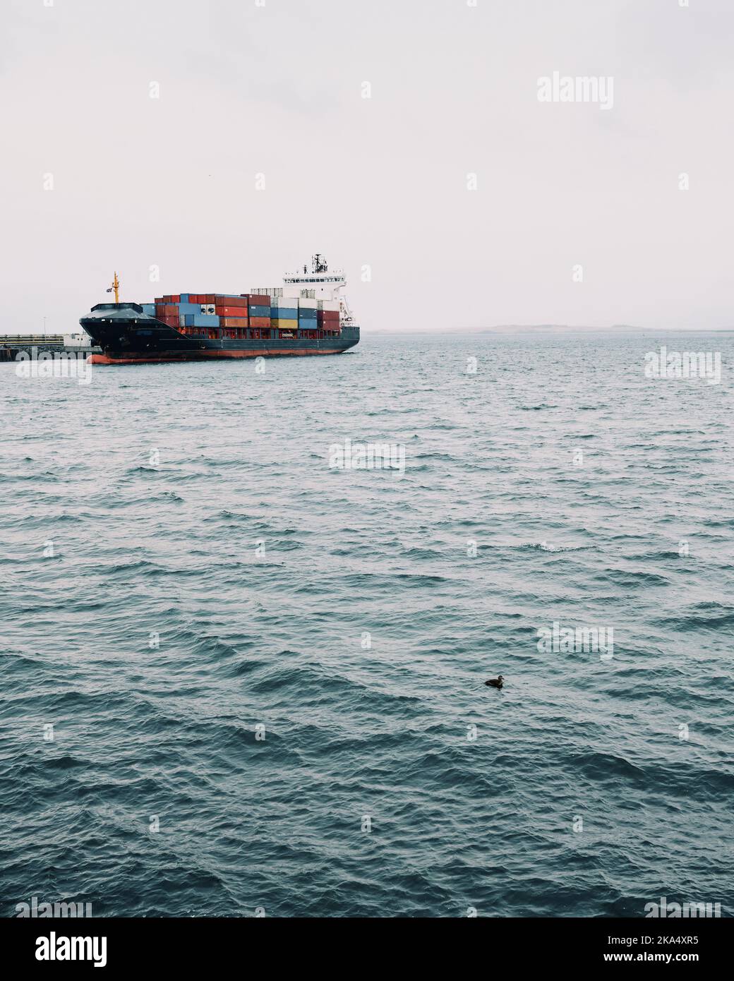 Cargo ship floating on wavy ocean Stock Photo - Alamy