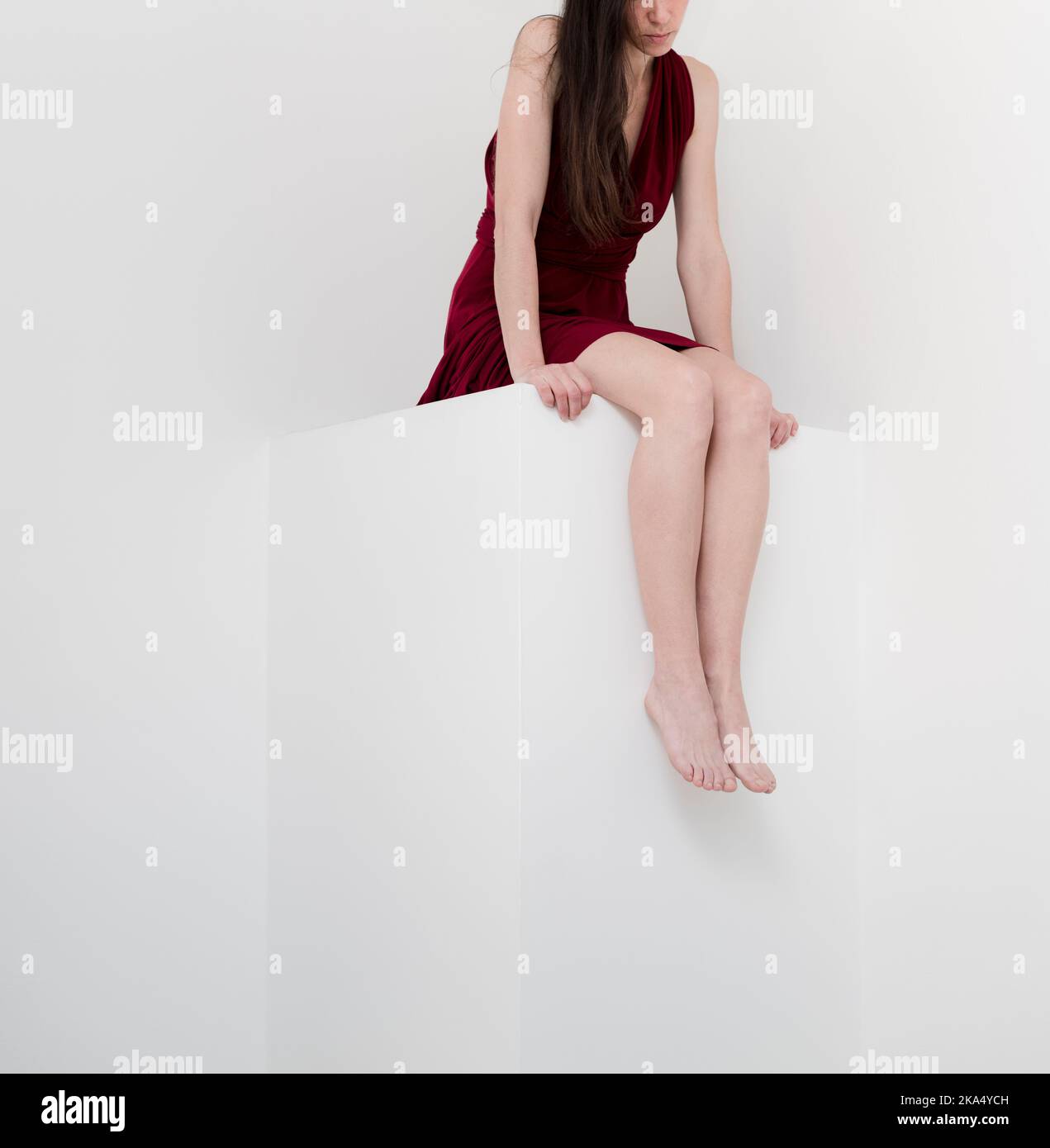 Surreal portrait of sitting woman on minimal white space Stock Photo ...