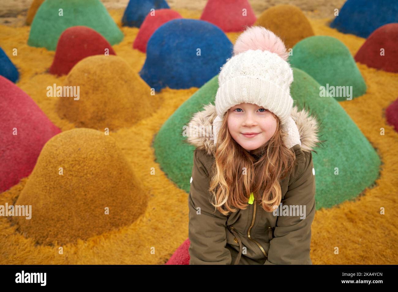 Little girl on multicolored playground in winter Stock Photo - Alamy
