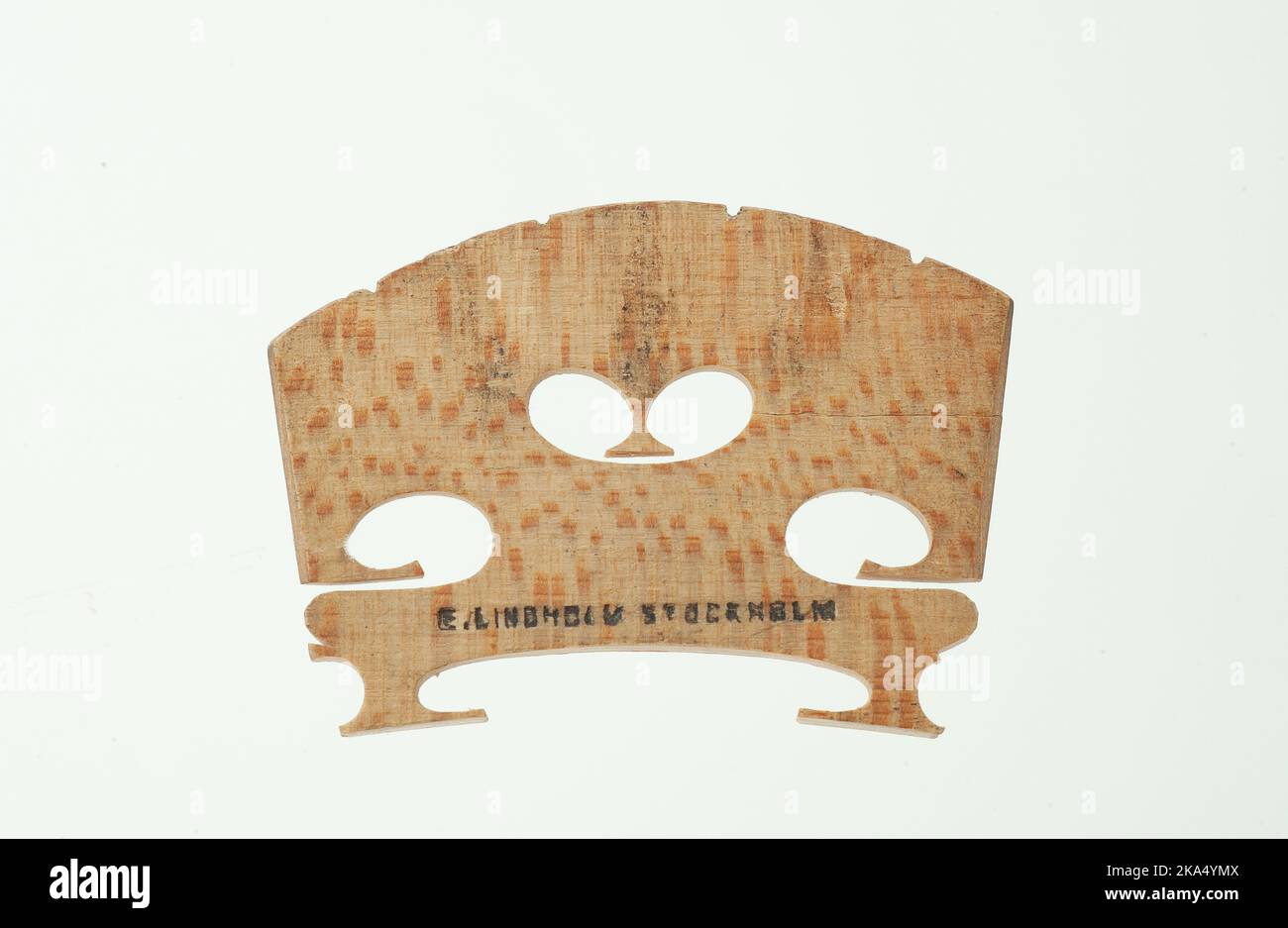 Close up of wooden string bridge for resting strings of violin or viola ...