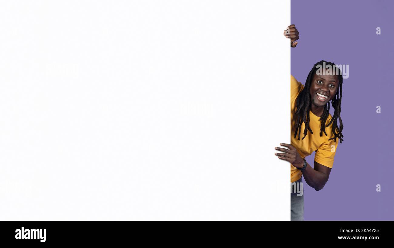 Positive black man standing by empty advert board Stock Photo - Alamy