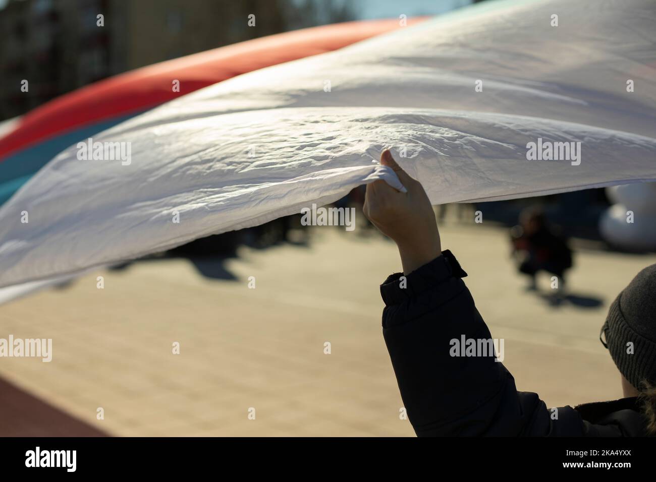 Hand holds flag of Russia. Hand holds on to fabric floating in air ...