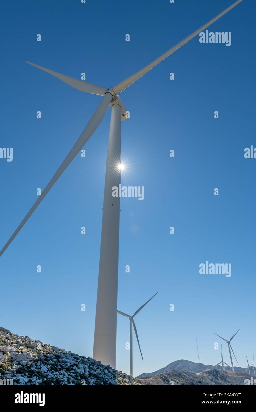 A mountain top wind farm with blue sky and sun light Stock Photo - Alamy