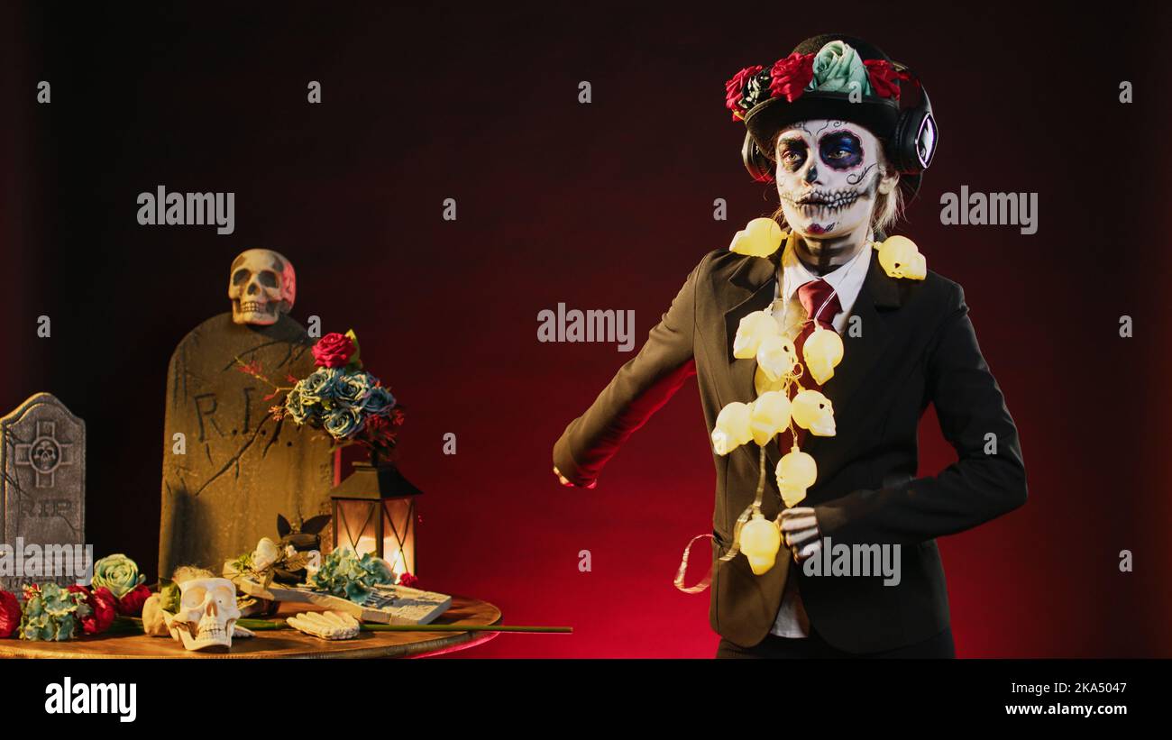 Model in lady of death costume suit dancing on music, listening to song ...