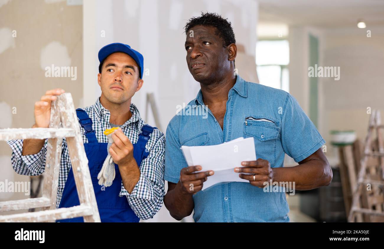 Owner of apartment indicates to foreman where and what to repair Stock ...