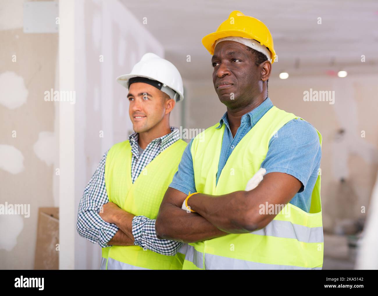 Portrait of two professional builders doing finishing work at cottage ...