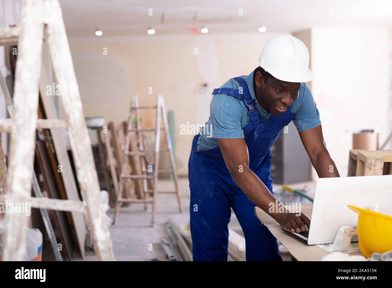 African american engineer checks a home renovation plan on a laptop ...