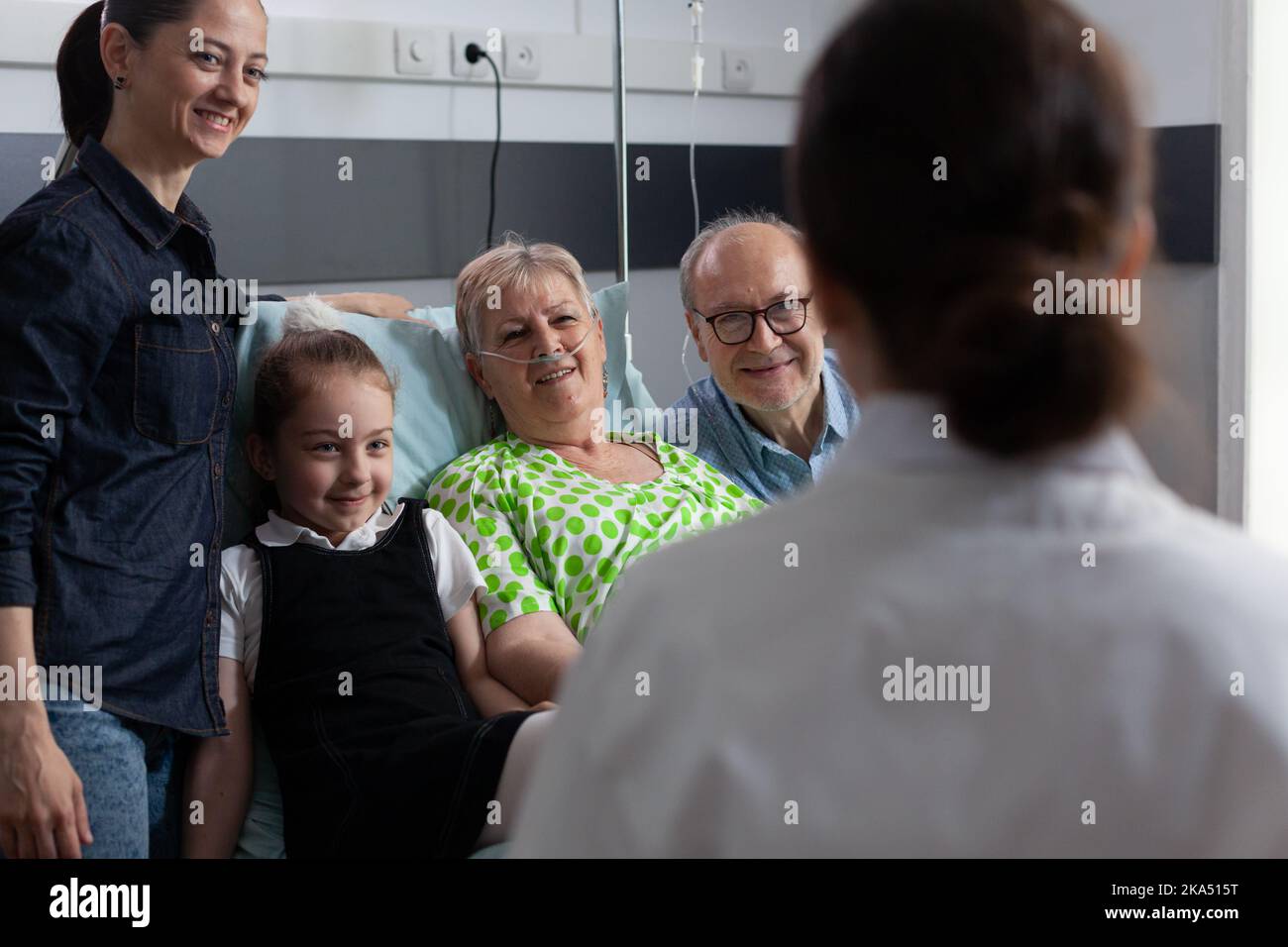 Female physician visiting elderly woman resting at sanatorium bed ...