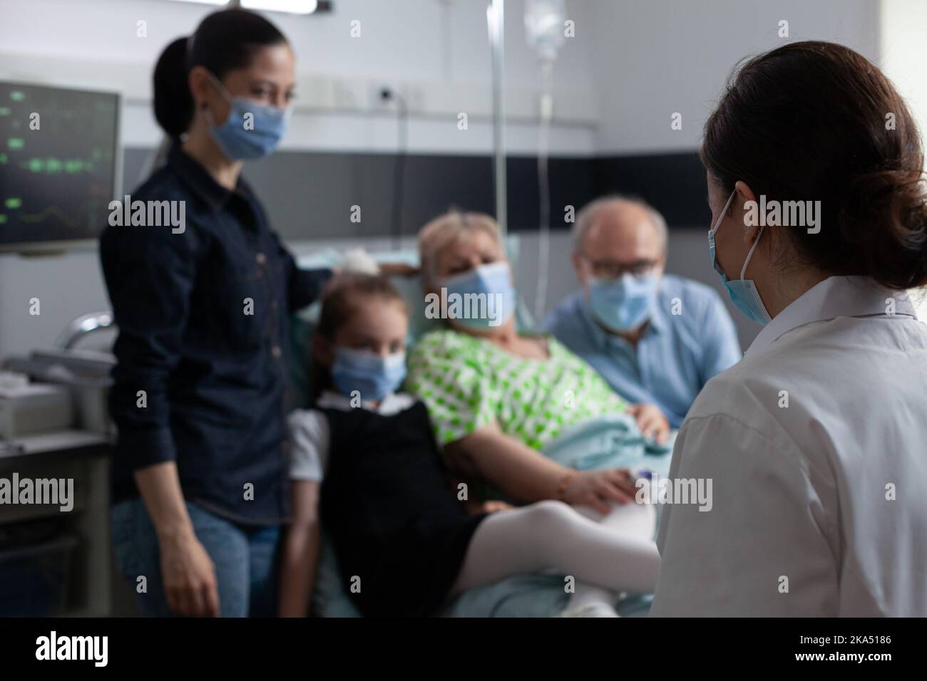 Unrecognizable doctor wearing cover up, visiting room to monitor ...