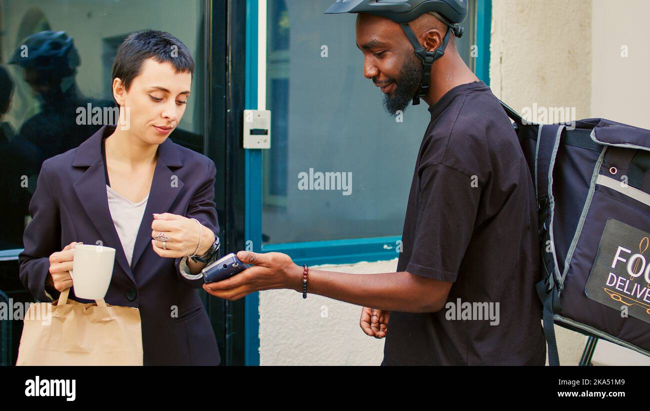 Food delivery employee giving food in paperbag to customer, client ...