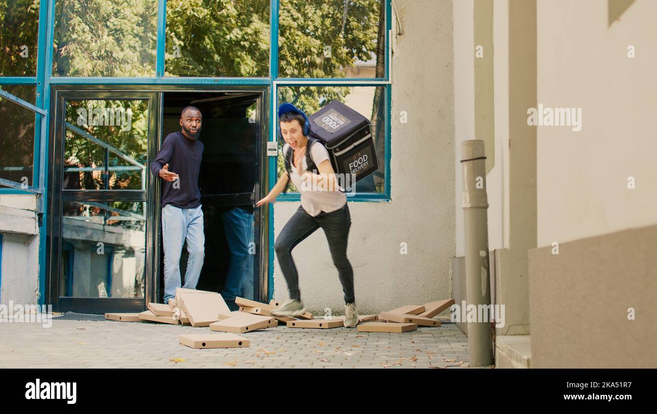 Fastfood delivery person dropping pizza boxes stack at client front ...