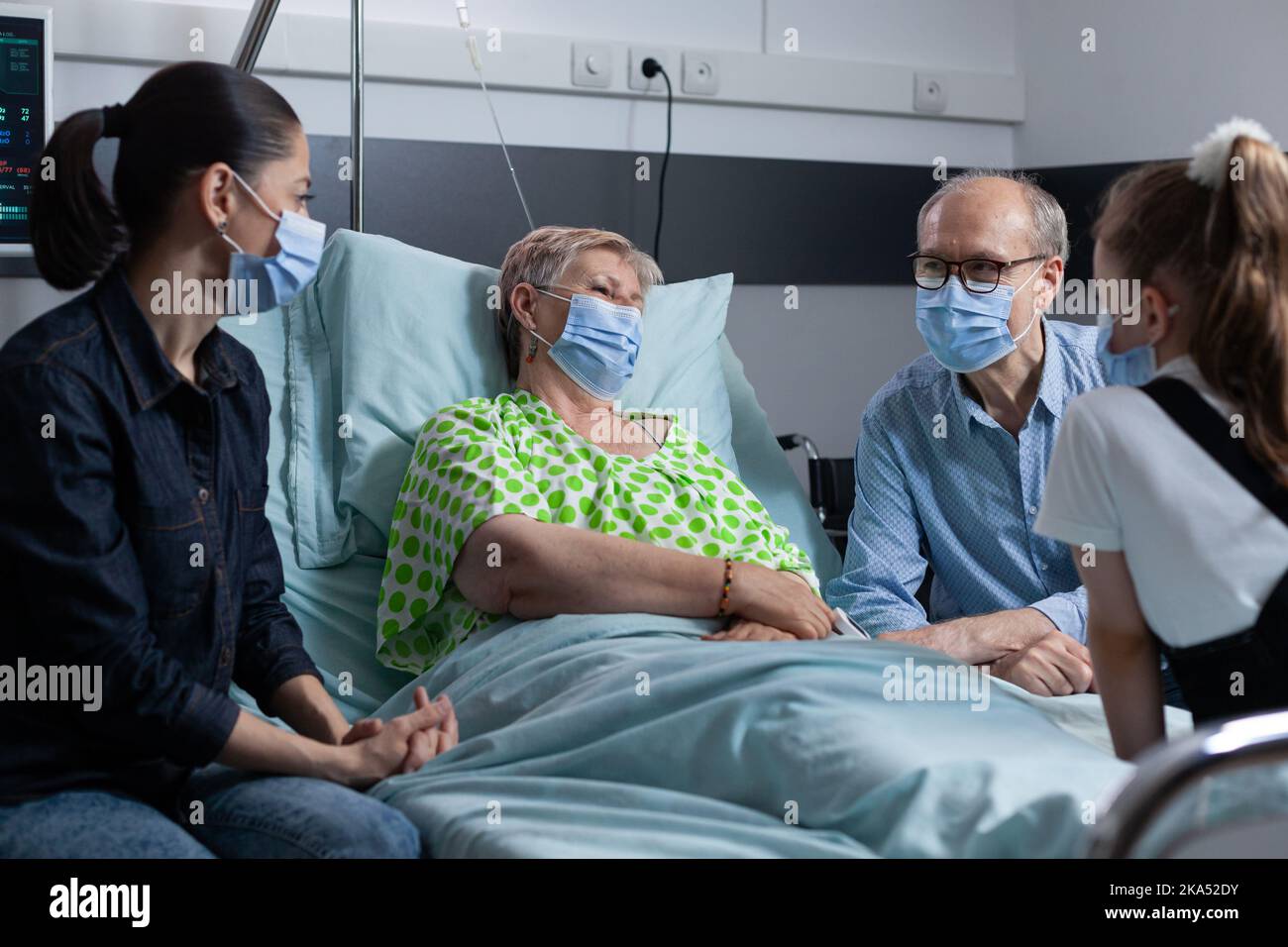 Elderly woman awaiting surgery with family members. Relatives chatting ...