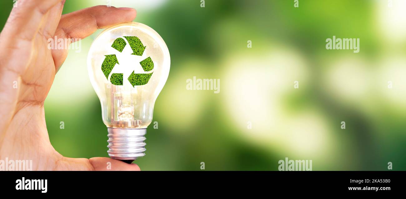 Close up photo of lightbulb with recycle icon with nature background as a symbol of reduce ...