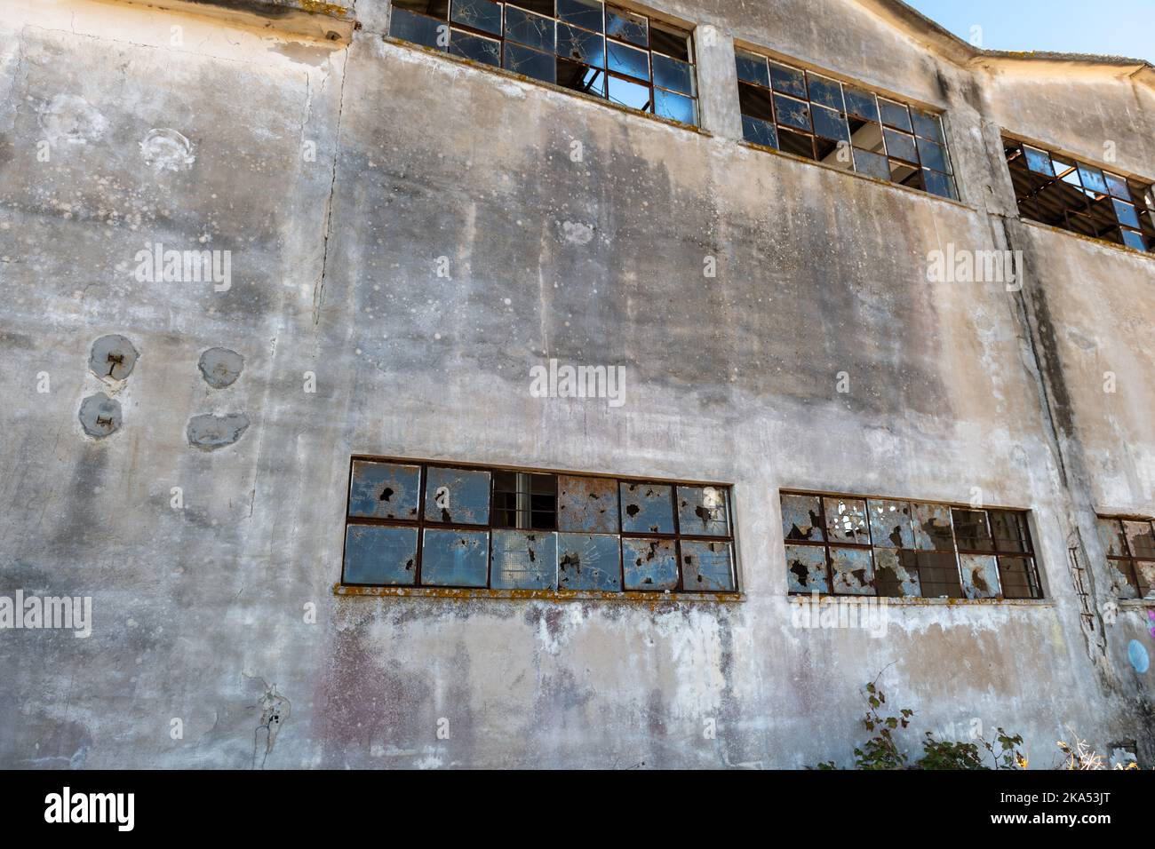 The broken windows of a derelict factory building Stock Photo - Alamy