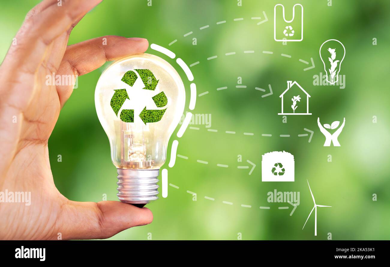 Close up photo of lightbulb with recycle icon with nature background as a symbol of reduce ...