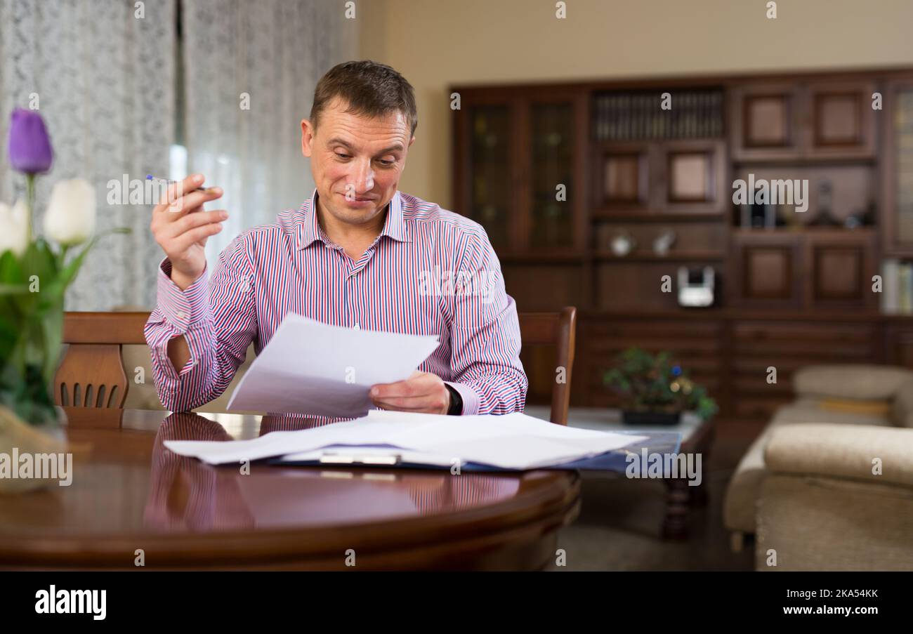 Concentrated man filling out papers Stock Photo - Alamy