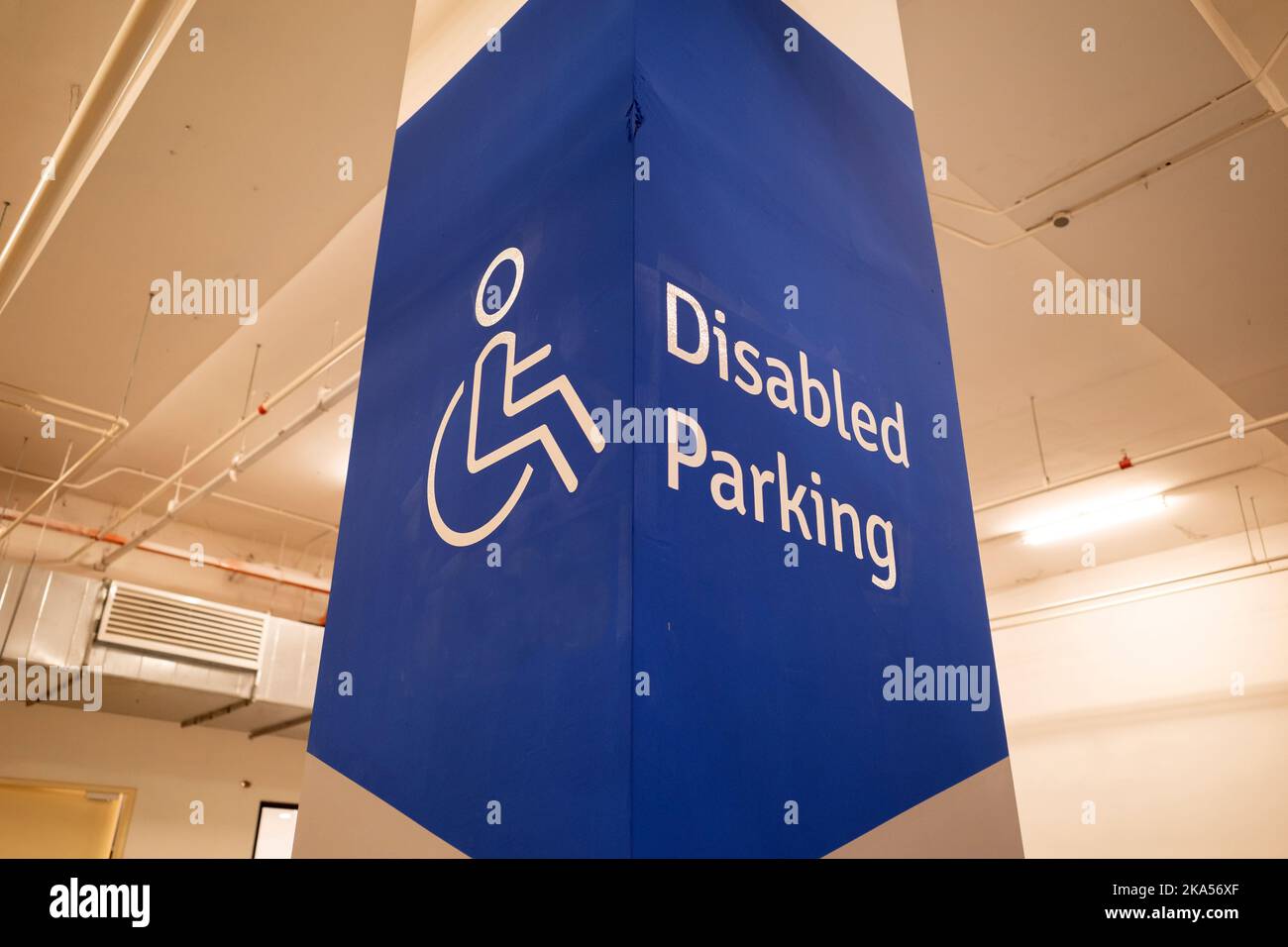 A disabled parking sign painted on a building column Stock Photo - Alamy