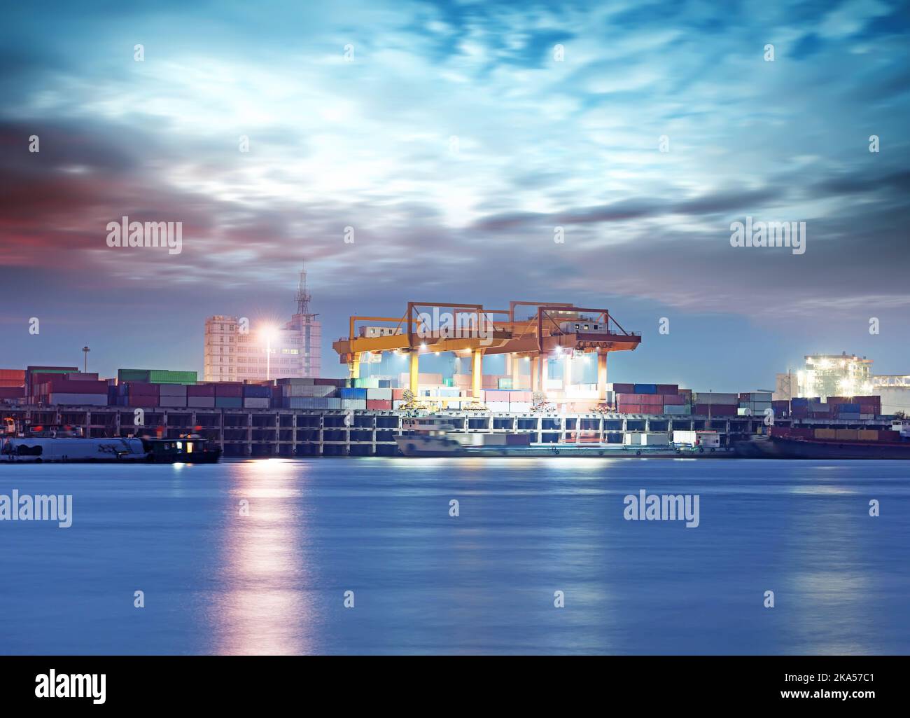 Container ship in the harbor, night shot. Cloudy sky Stock Photo - Alamy