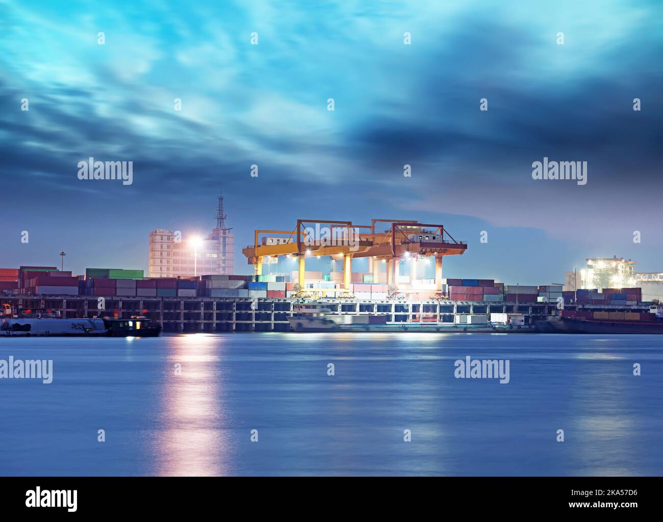 Container ship in the harbor, night shot. Cloudy sky Stock Photo - Alamy