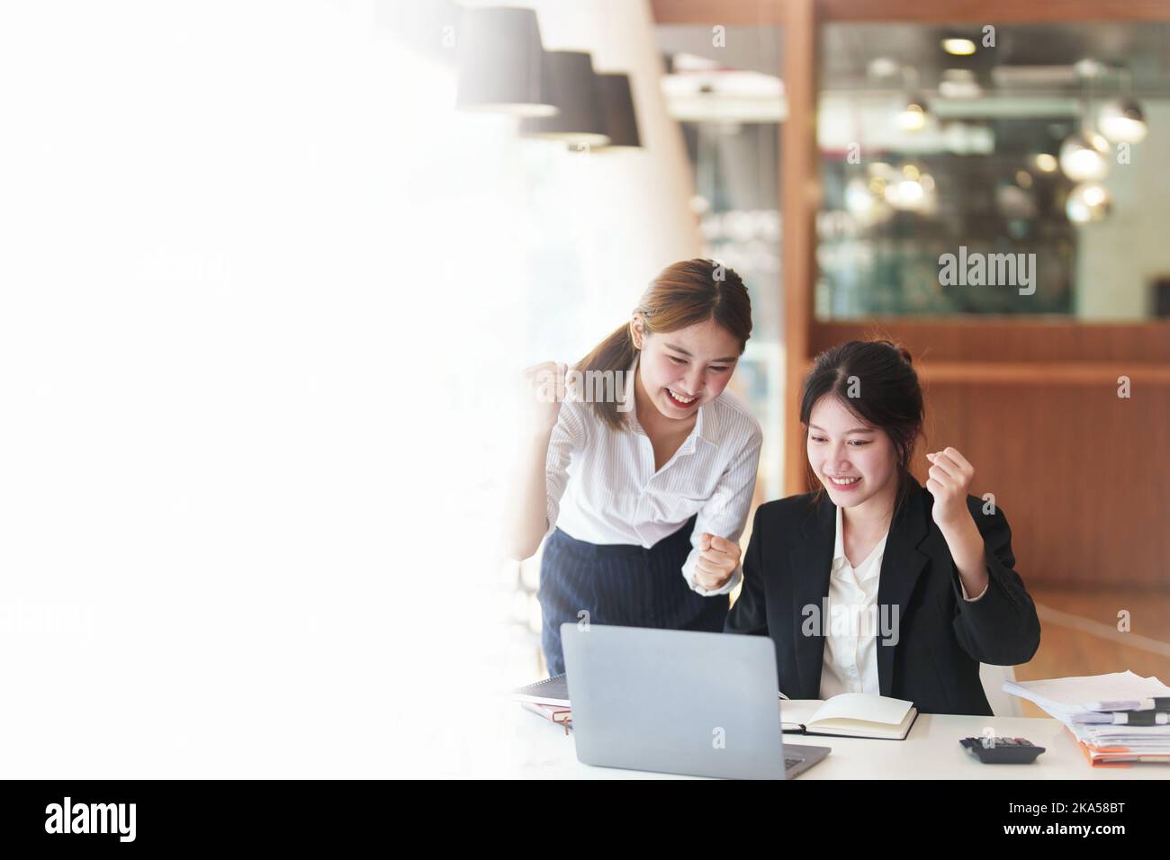 A portrait of two Asian business woman showing joy from sales of new ...