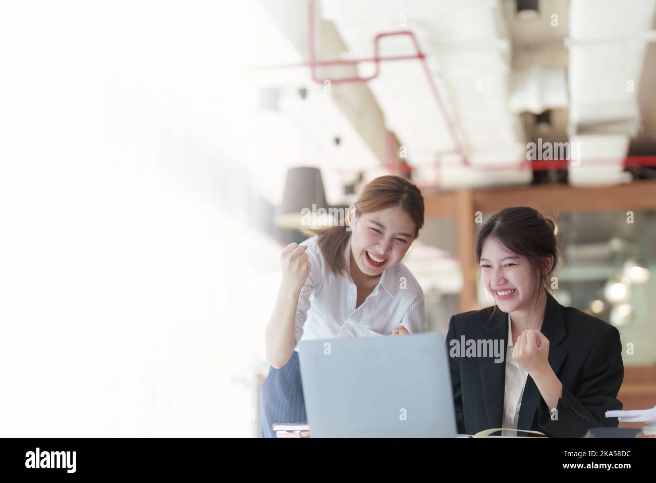 A portrait of two Asian business woman showing joy from sales of new ...