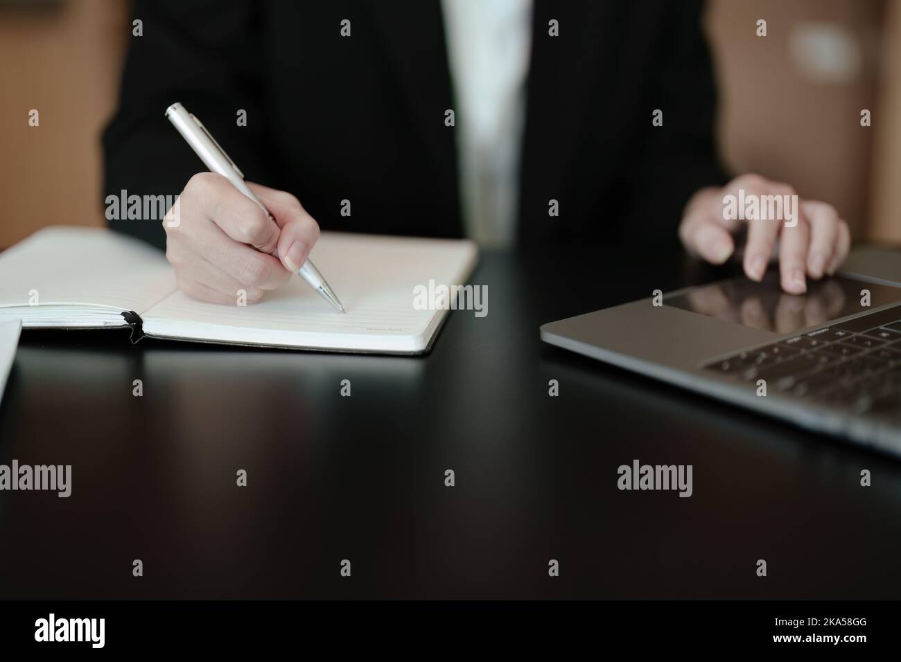 usiness woman writing marketing plan in notebook ready to use computer ...