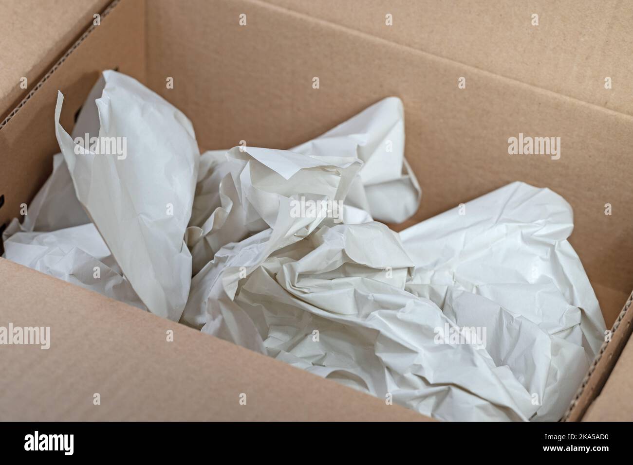 Empty cardboard box with crumpled wrapping paper Stock Photo - Alamy