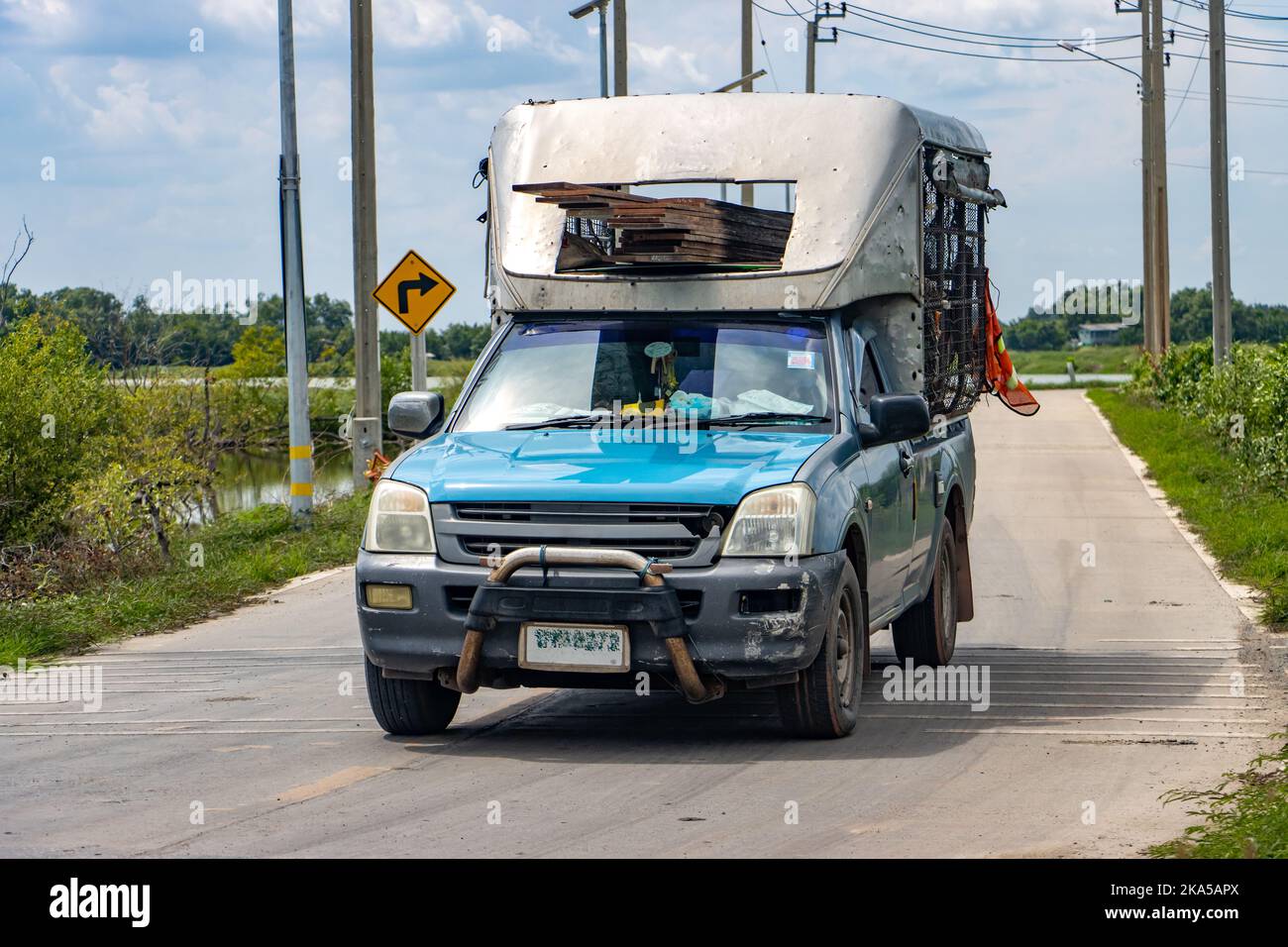 A pickup car with load ride on the rural road Stock Photo - Alamy
