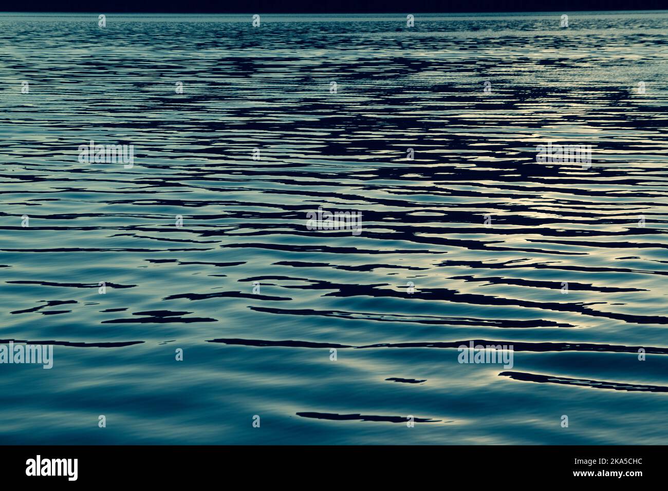 Colors and light reflected in the blue water waves Stock Photo - Alamy