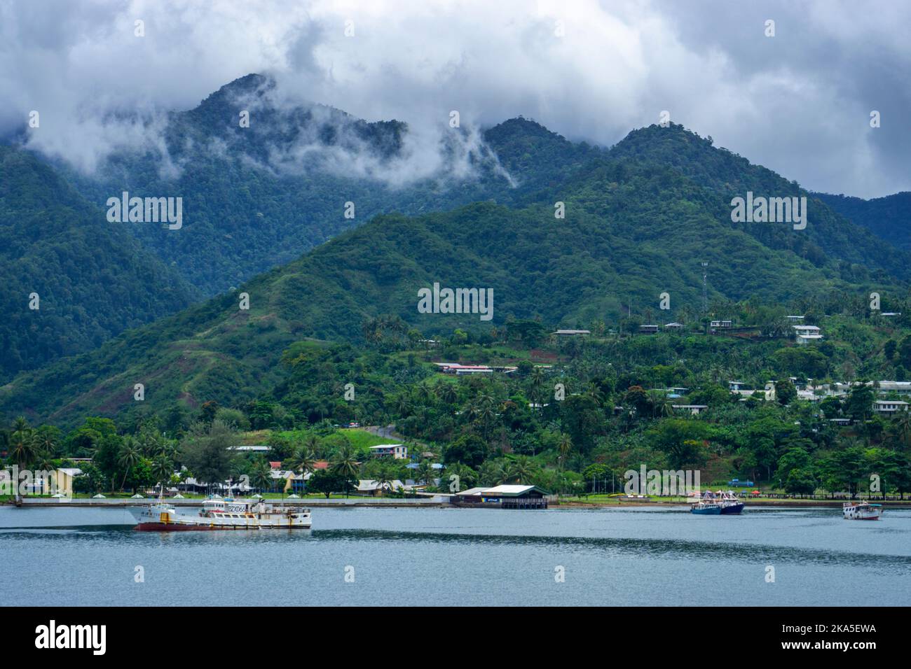 Alotau harbour at the foothills of the jungle covered Owen Stanley ...