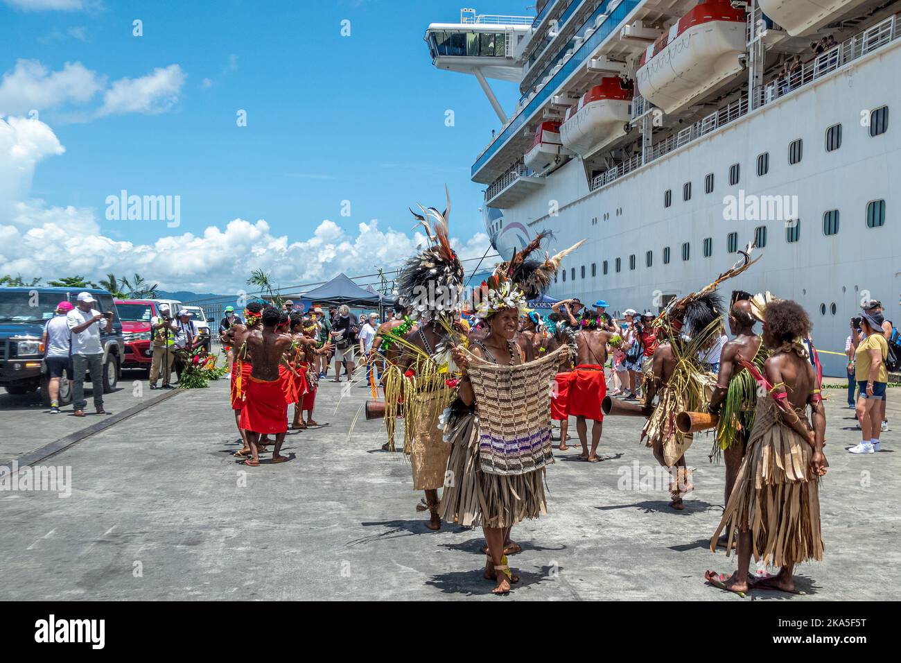Indigenous dancers in traditional costume greet the arrival of a cruise ...