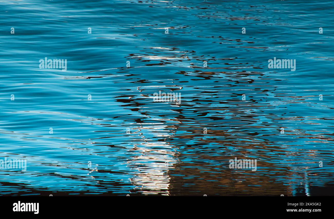 Colors and light reflected in the blue water waves Stock Photo - Alamy